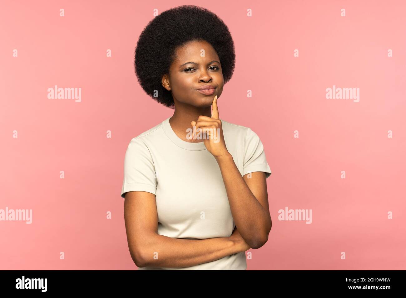 Doubtful black woman touching chin, frowning, pondering, looking at ...