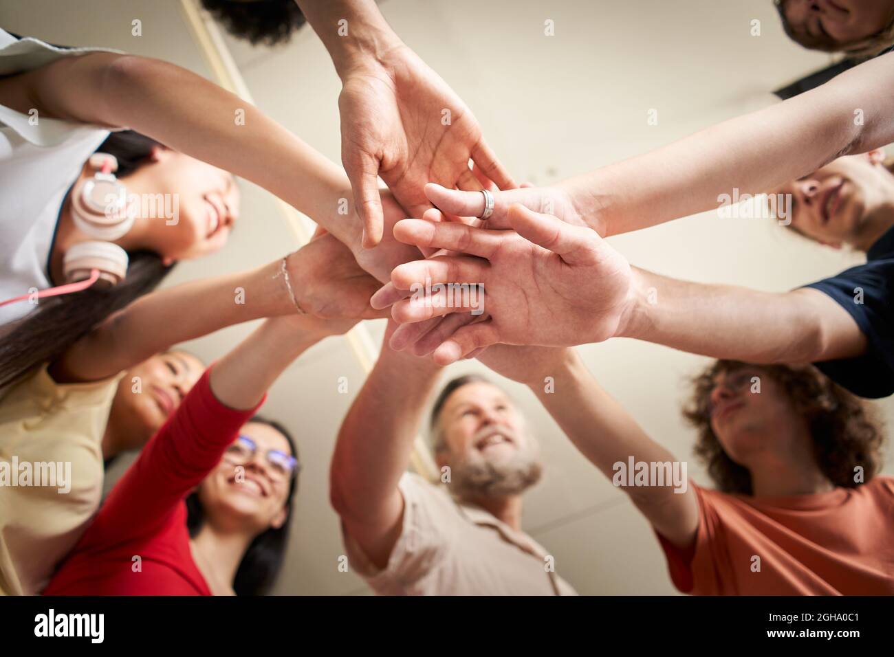 bottom view. group of happy young people making a tower out of their ...