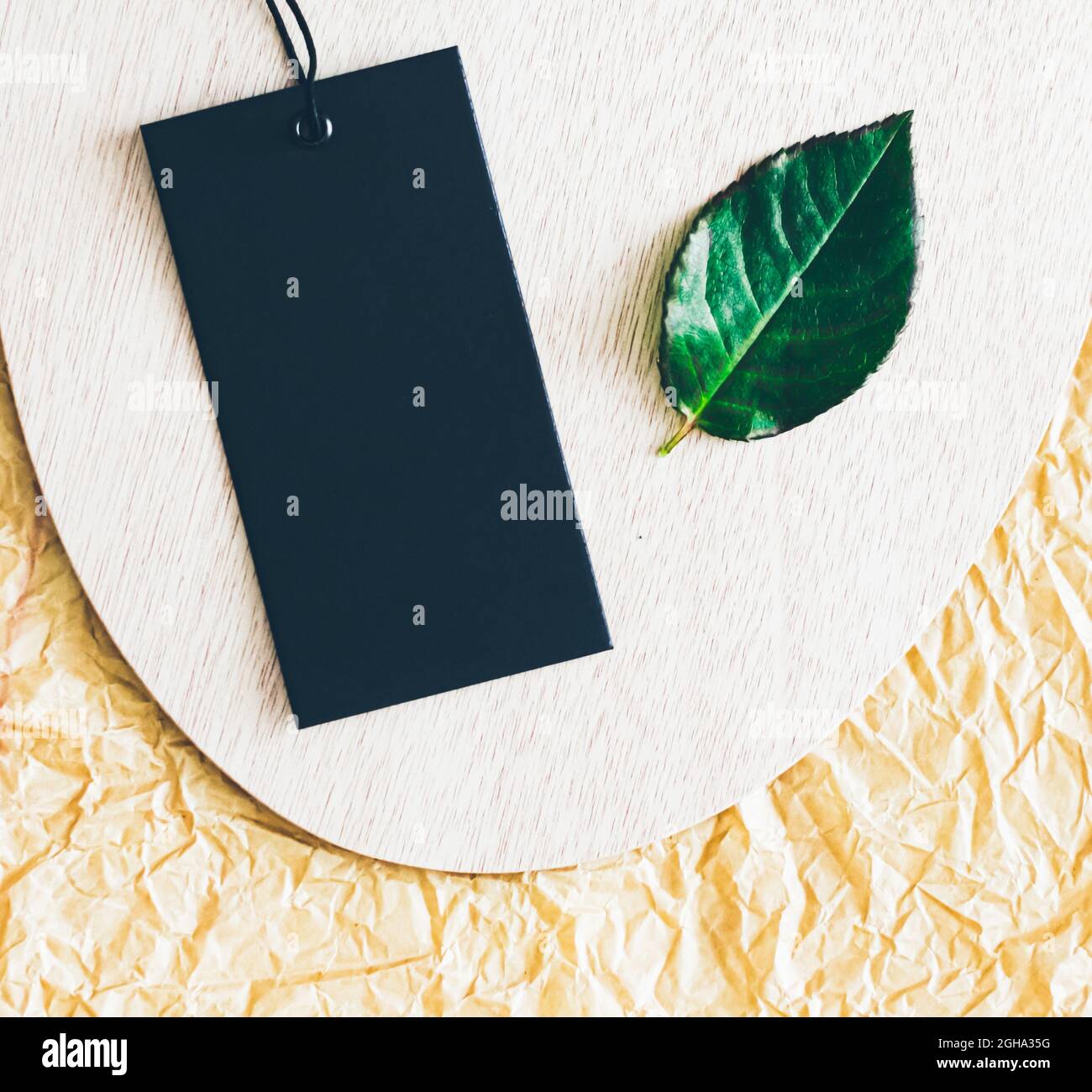 Price tag and green leaf on natural materials background, sustainable ...