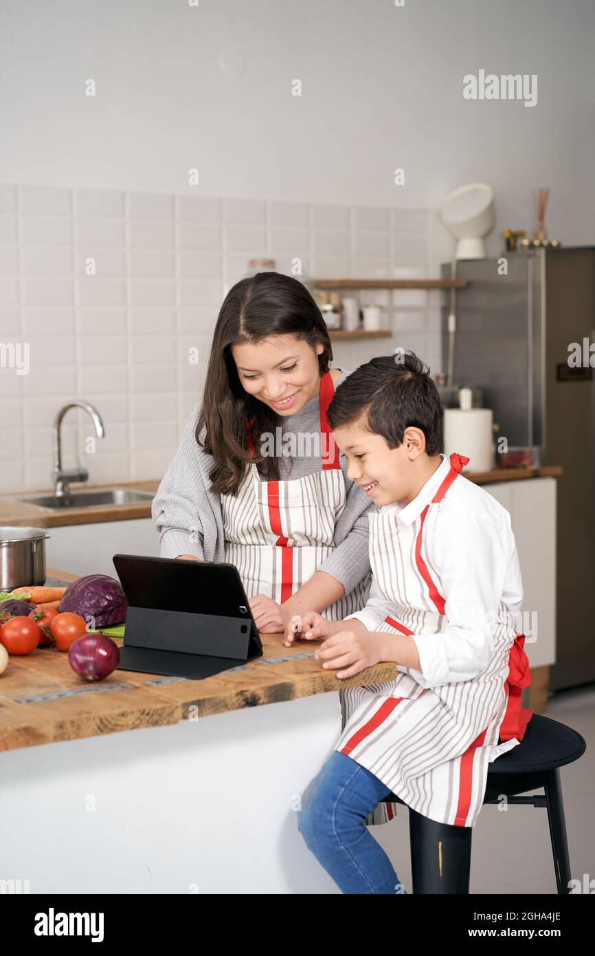 Vertical photo. In the kitchen: A single-parent family cooking. Mother ...