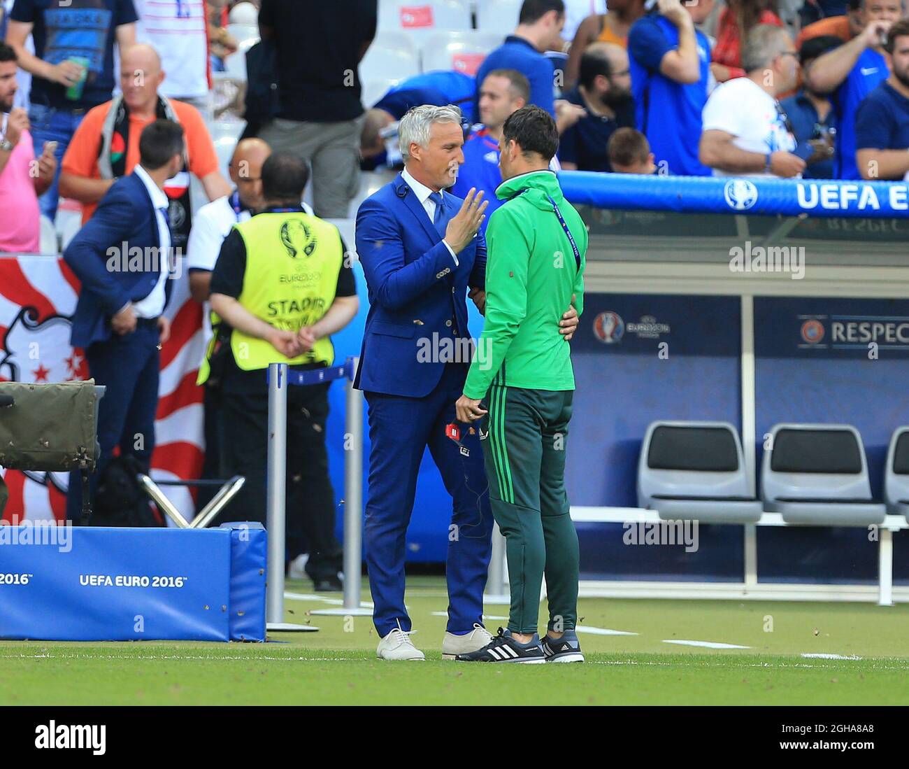 Former player David Ginola chats to referee Mark Clattenburg during the ...