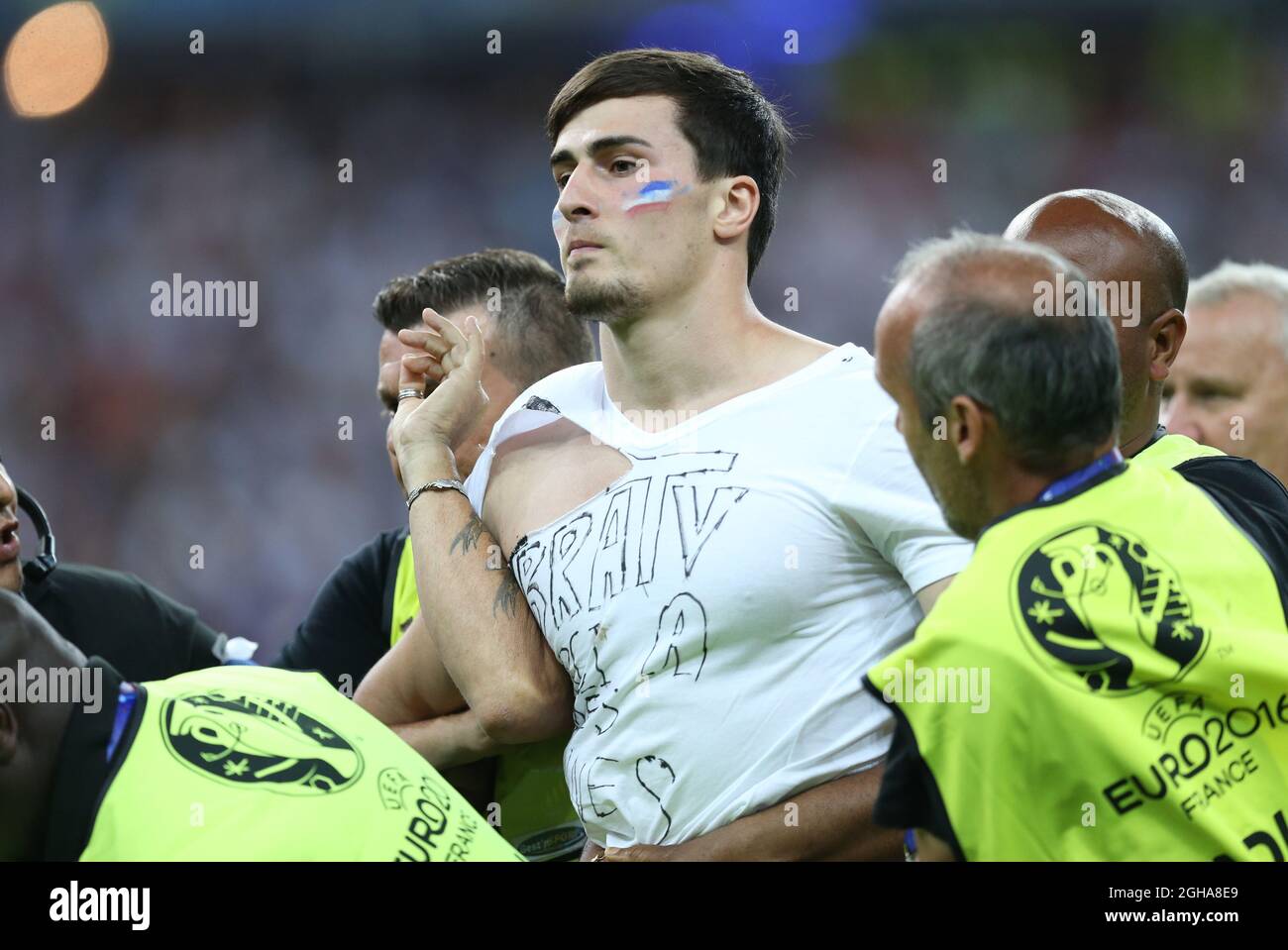 A pitch invader is escorted off the pitch during the UEFA European ...