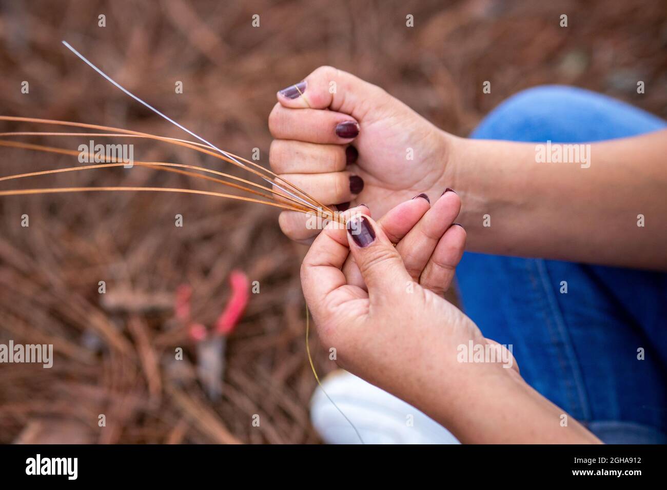Selective focus of a woman making a handcraft made of dried pine tree ...