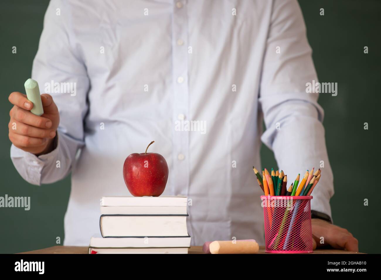 Back to school concept: teacher giving books to her studens in the ...