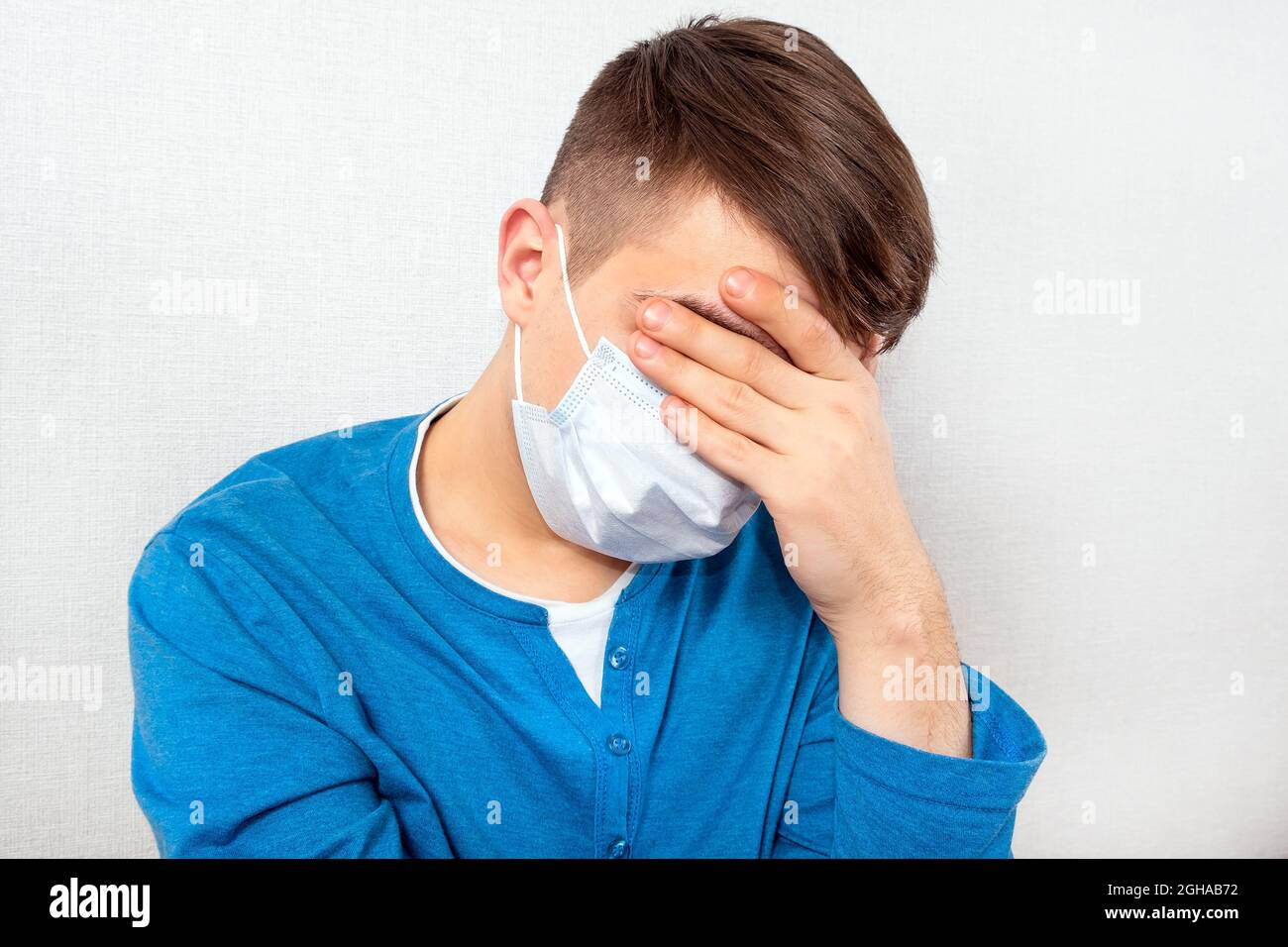 Sad and Tired Young Man in a Flu Mask by the Wall in the Room Stock ...