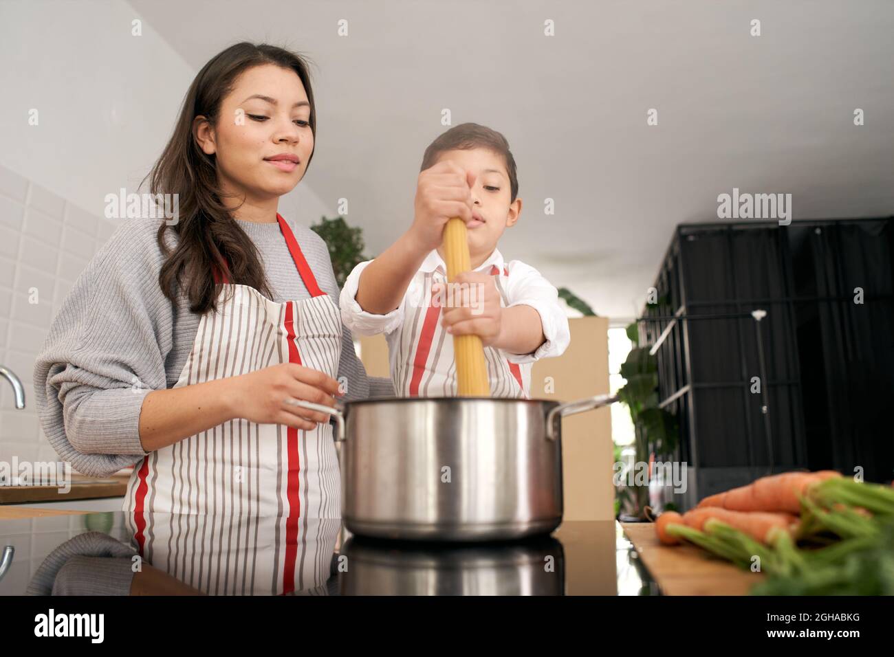 In the kitchen: A single-parent family cooking pasta together. Mother ...