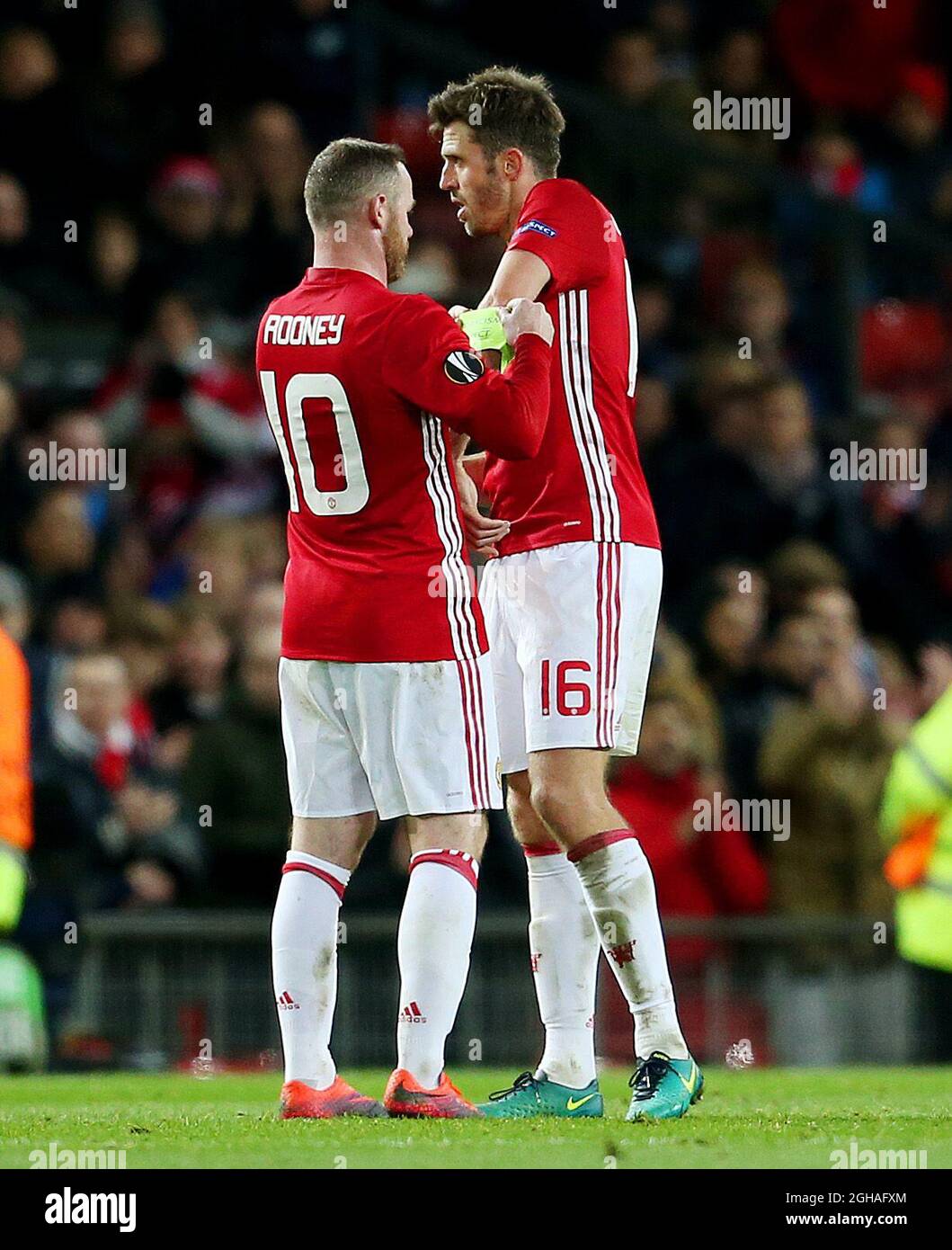 Wayne Rooney of Manchester United hands the captains armband to team ...