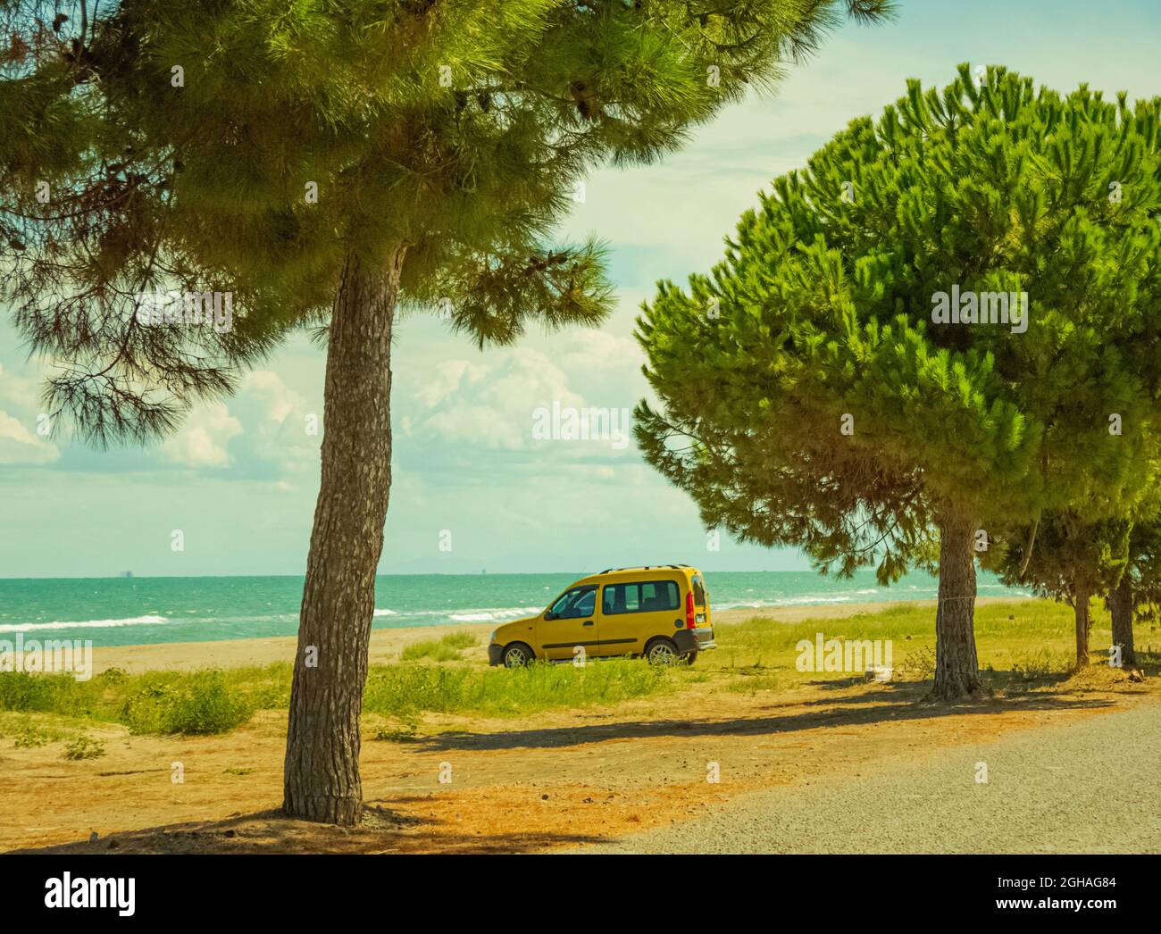 Yellow minivan sitting on the beach. Enjoying the seaside Stock Photo ...
