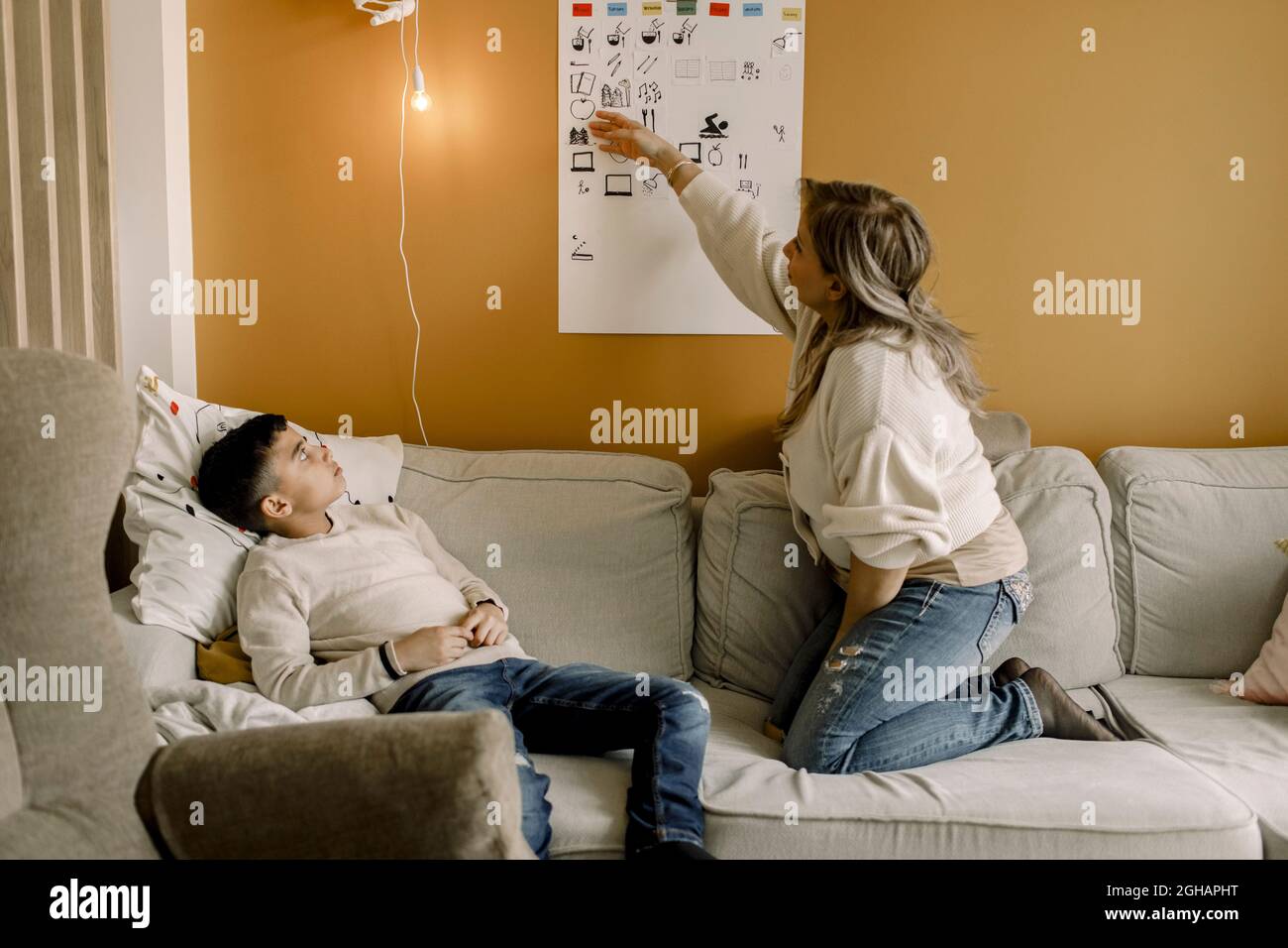 Mother teaching autistic son in living room Stock Photo - Alamy