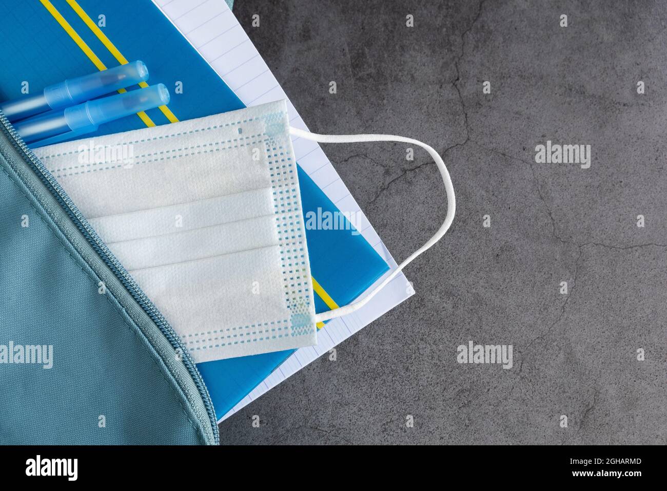 Mask in backpack with books Stock Photo - Alamy