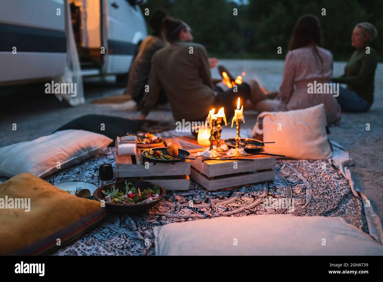 Female and male friends talking by camping van during vacation Stock ...