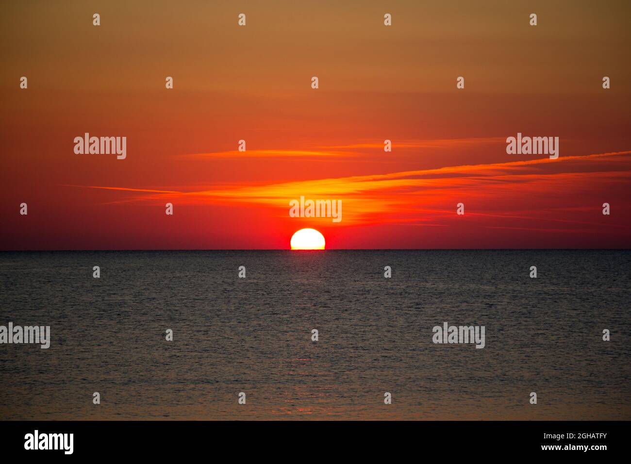 Beautiful red orange sunset by the sea in Croatia - Sun partly touching ...