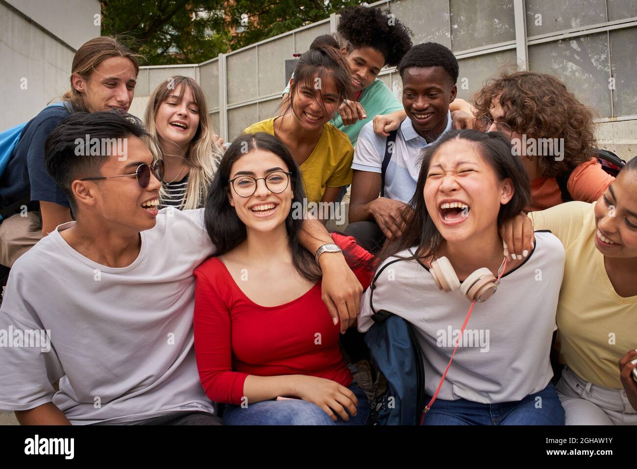A girl surrounded by classmates looking at a smiling camera. Happy ...