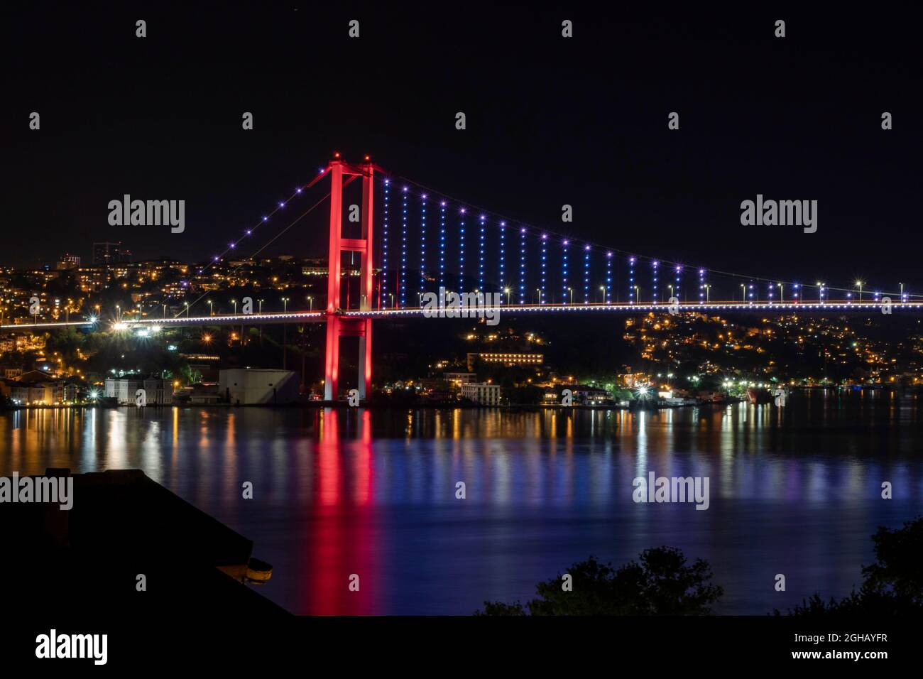 Bosporus bridge with lights with reflection on sea at night in Istanbul ...