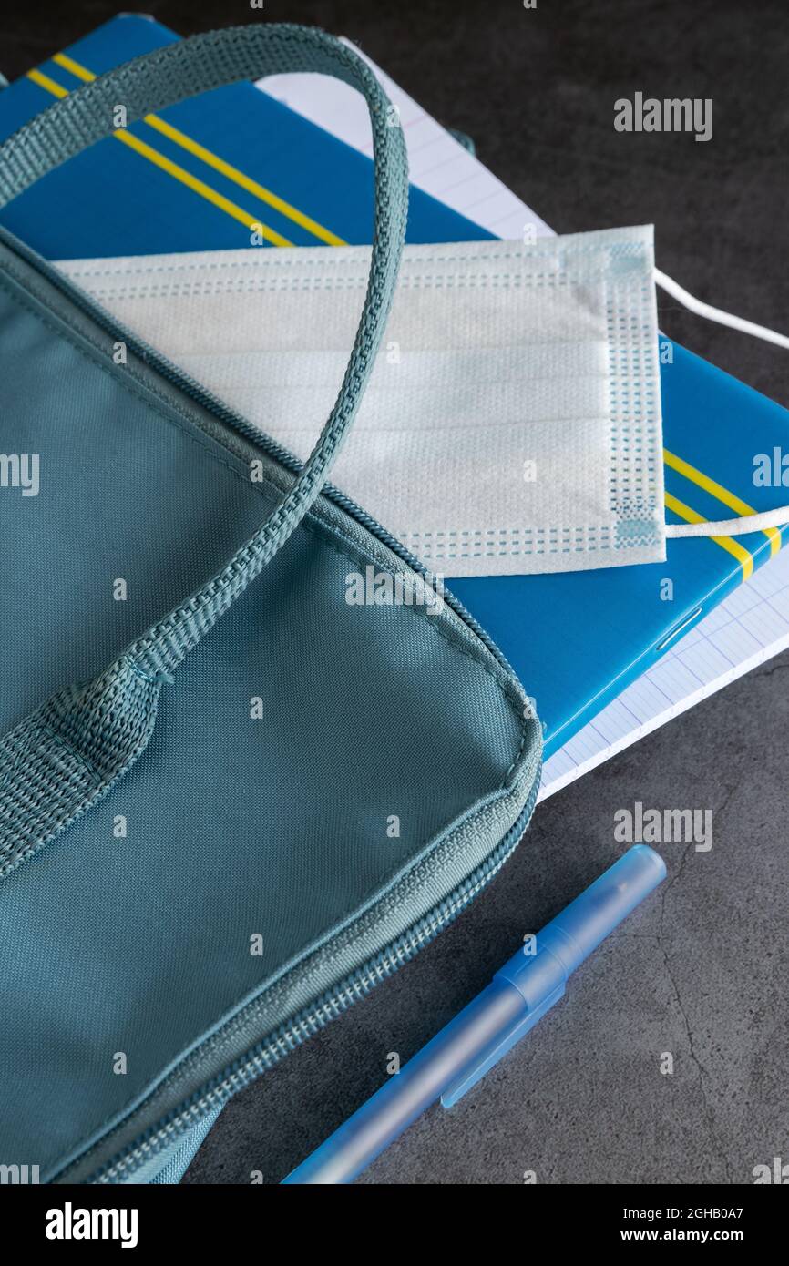 Mask in backpack with books Stock Photo - Alamy
