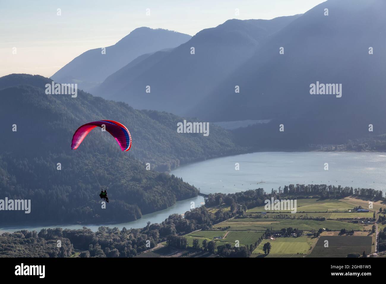 Adventurous people Paragliding around the Canadian mountains Stock ...