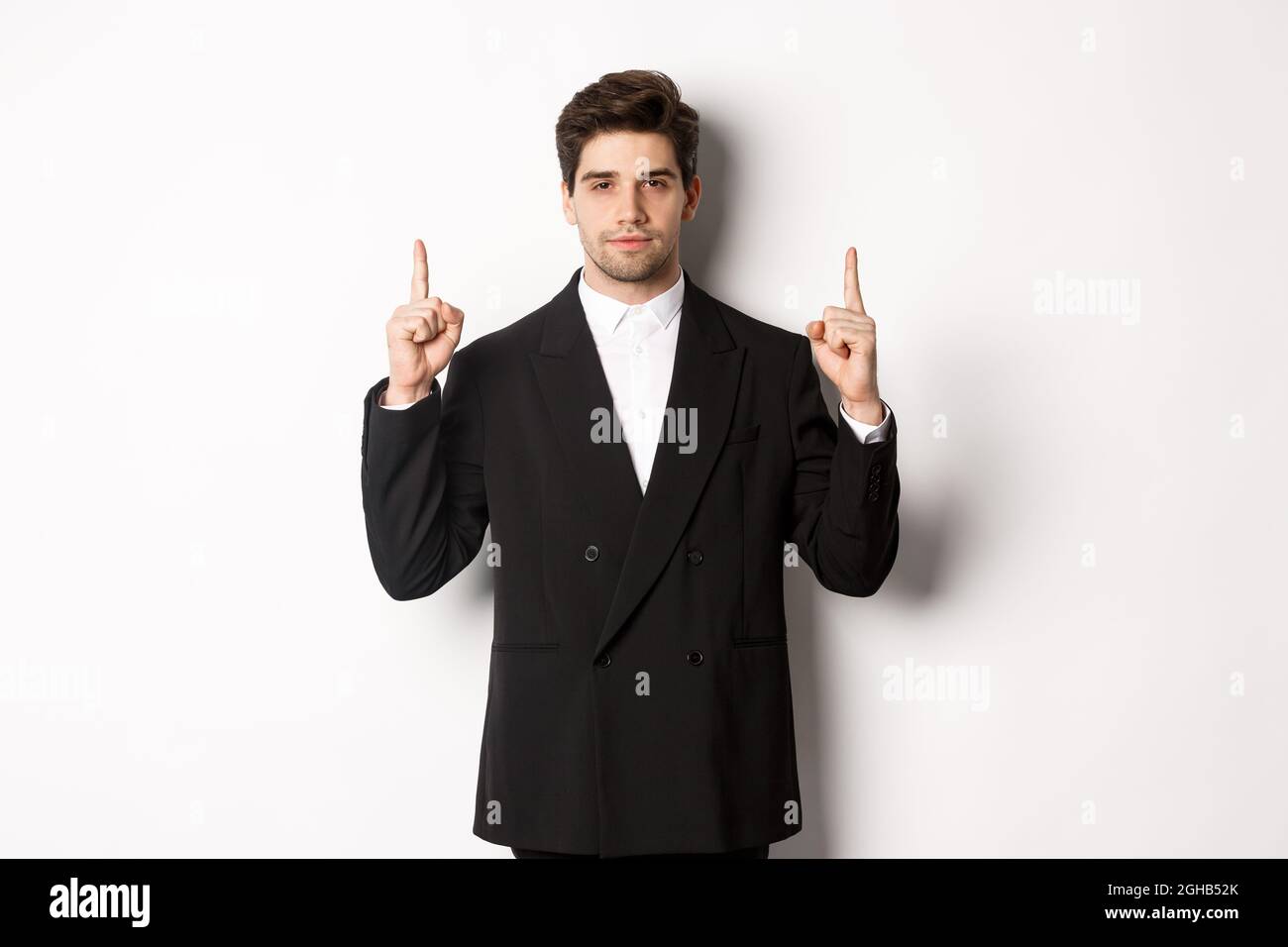Image of confident and handsome man in formal suit, pointing fingers up ...