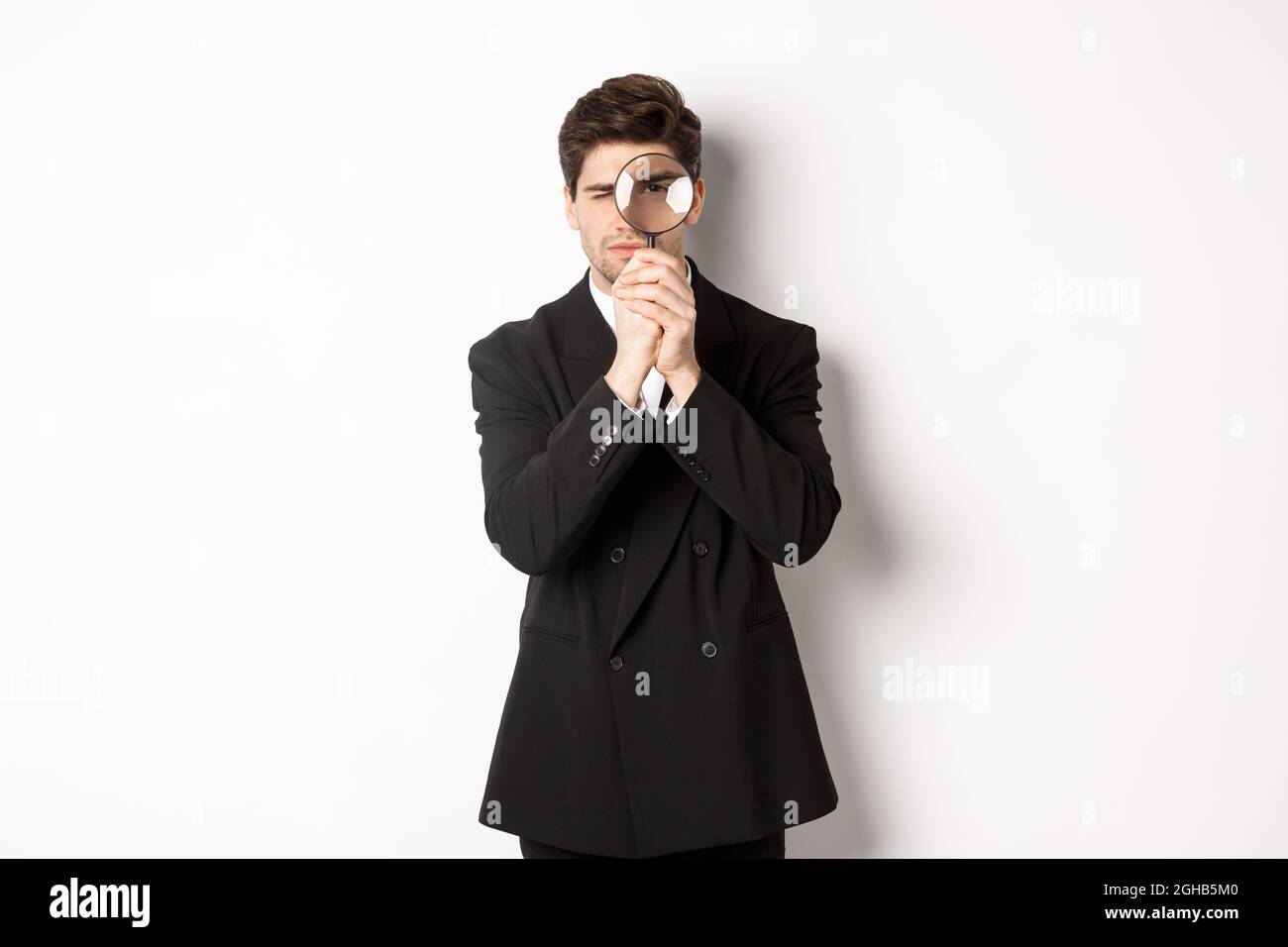 Image of serious businessman in black trendy suit, looking through ...