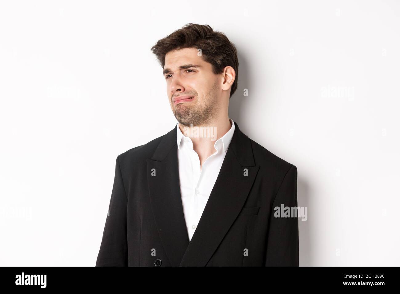 Close-up of disgusted young man in trendy suit, grimacing upset ...