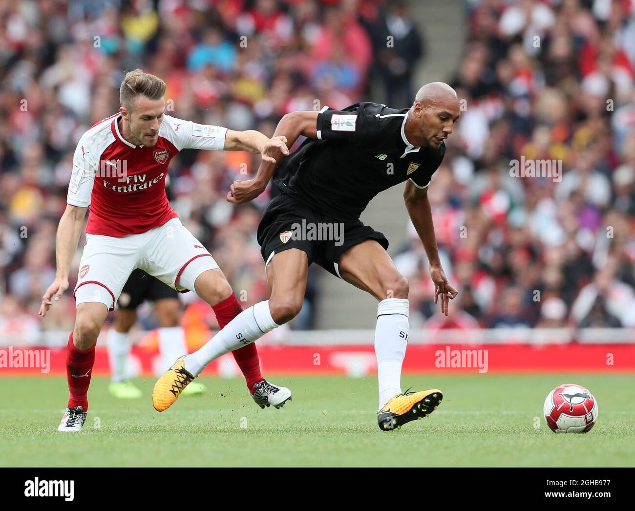 Arsenal's Aaron Ramsey tussles with Steven Nâ€™Zonzi of Sevilla during ...