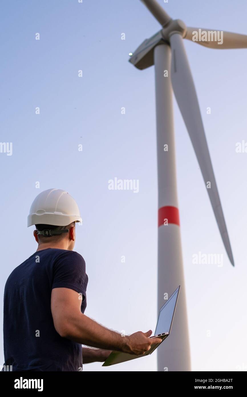 Male engineer in the helmet controls and maintains the operation of a ...