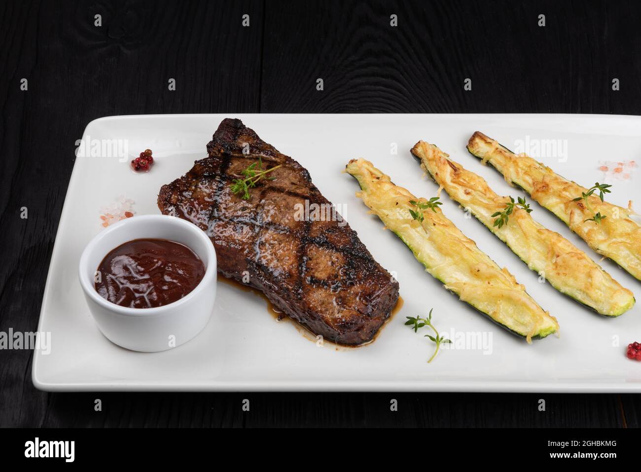 Grilled black angus strip loin steak New York with zucchini on white ...
