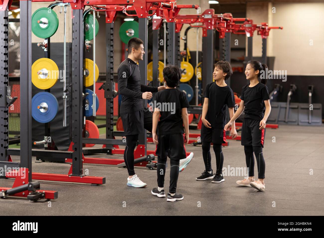 Active children having exercise class with their coach in gym Stock ...