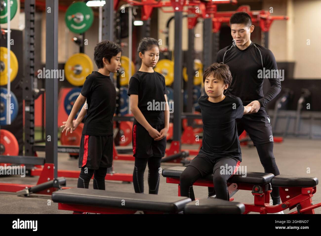 Active children having exercise class with their coach in gym Stock ...