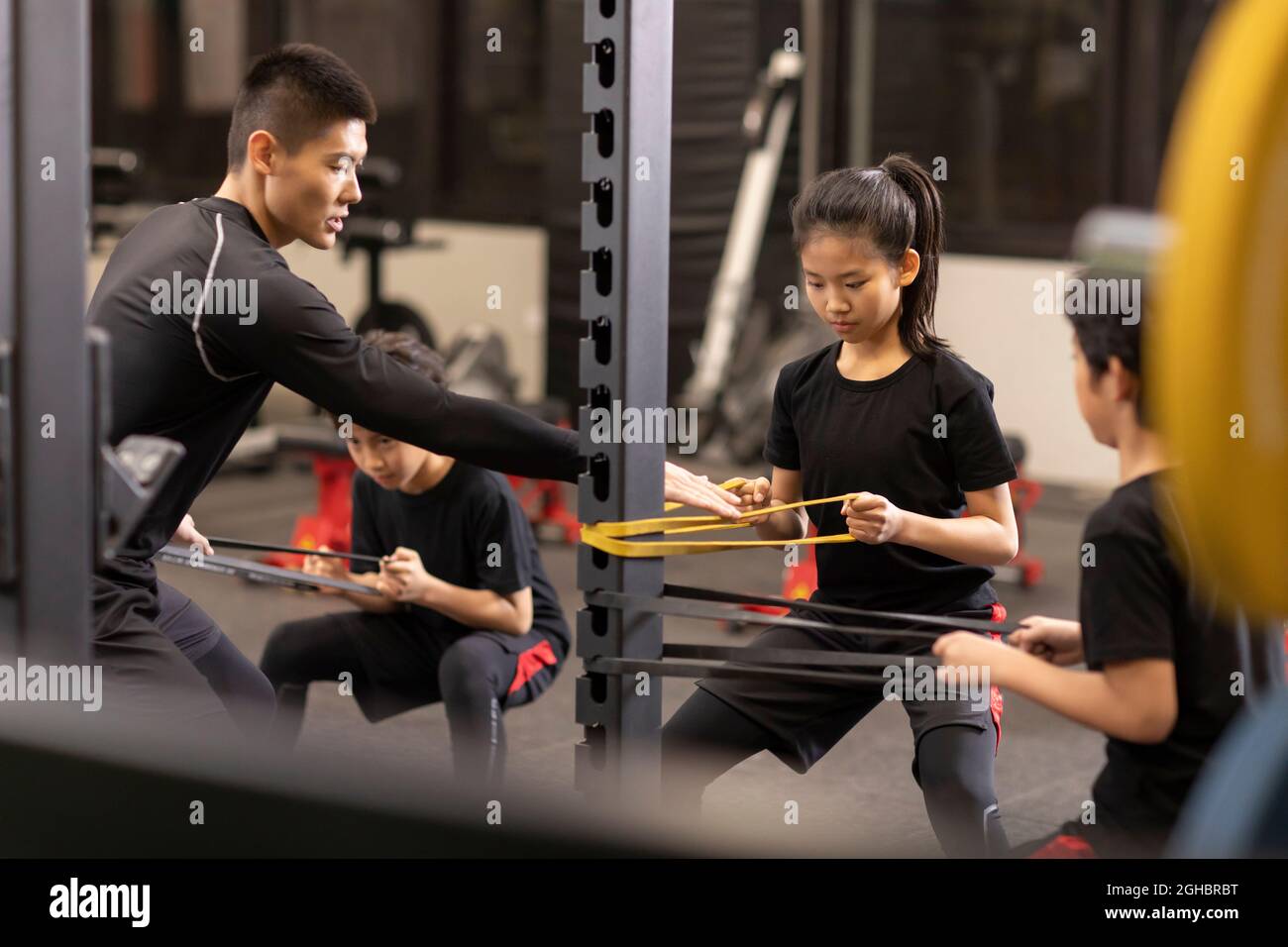 Active children having exercise class with their coach in gym Stock ...