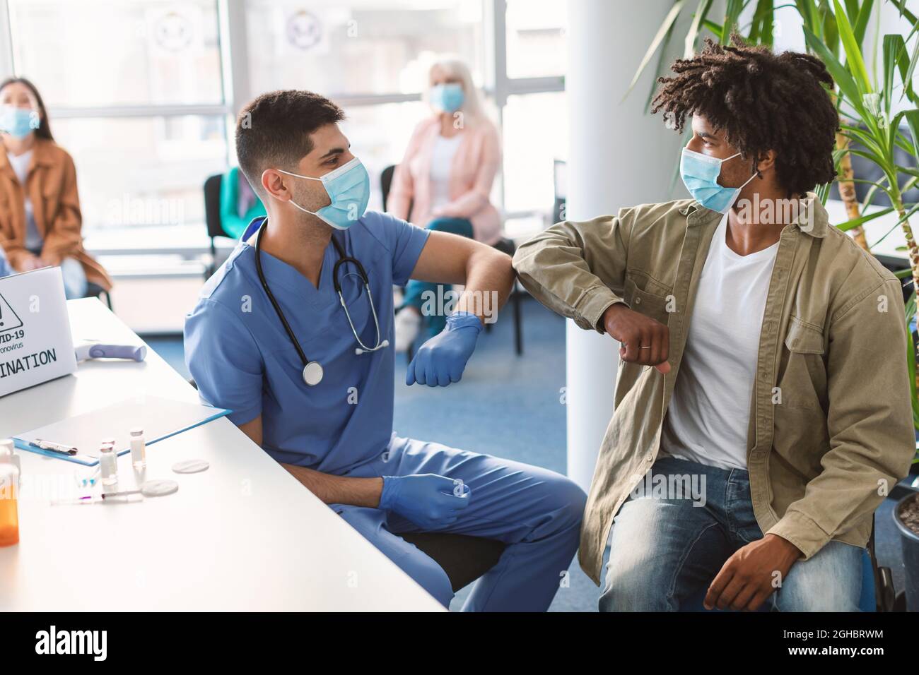 Black Guy In Medical Mask Bumping Elbows Meeting Male Doctor Stock ...