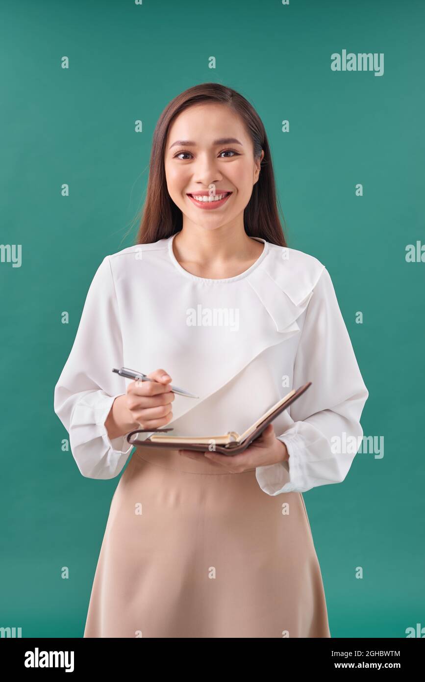 Pretty young beautiful woman standing, writing, take notes, holding ...