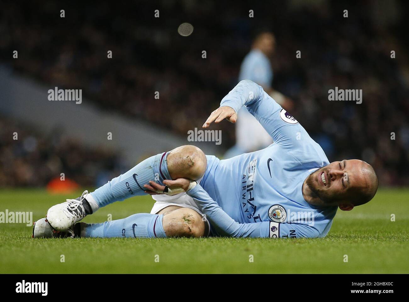 David Silva of Manchester City shouts out for help following an injury ...