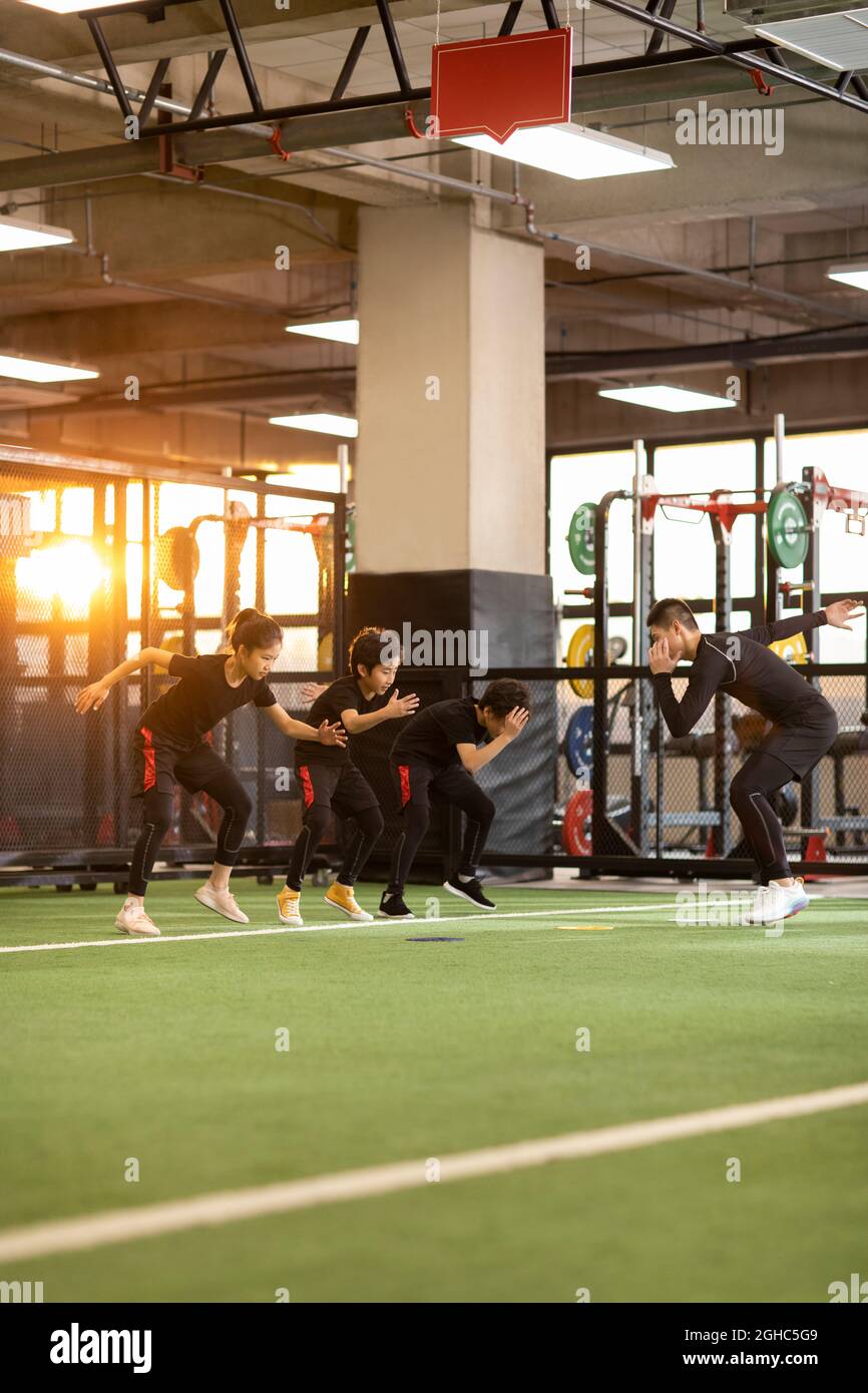 Active children having exercise class with their coach in gym Stock ...
