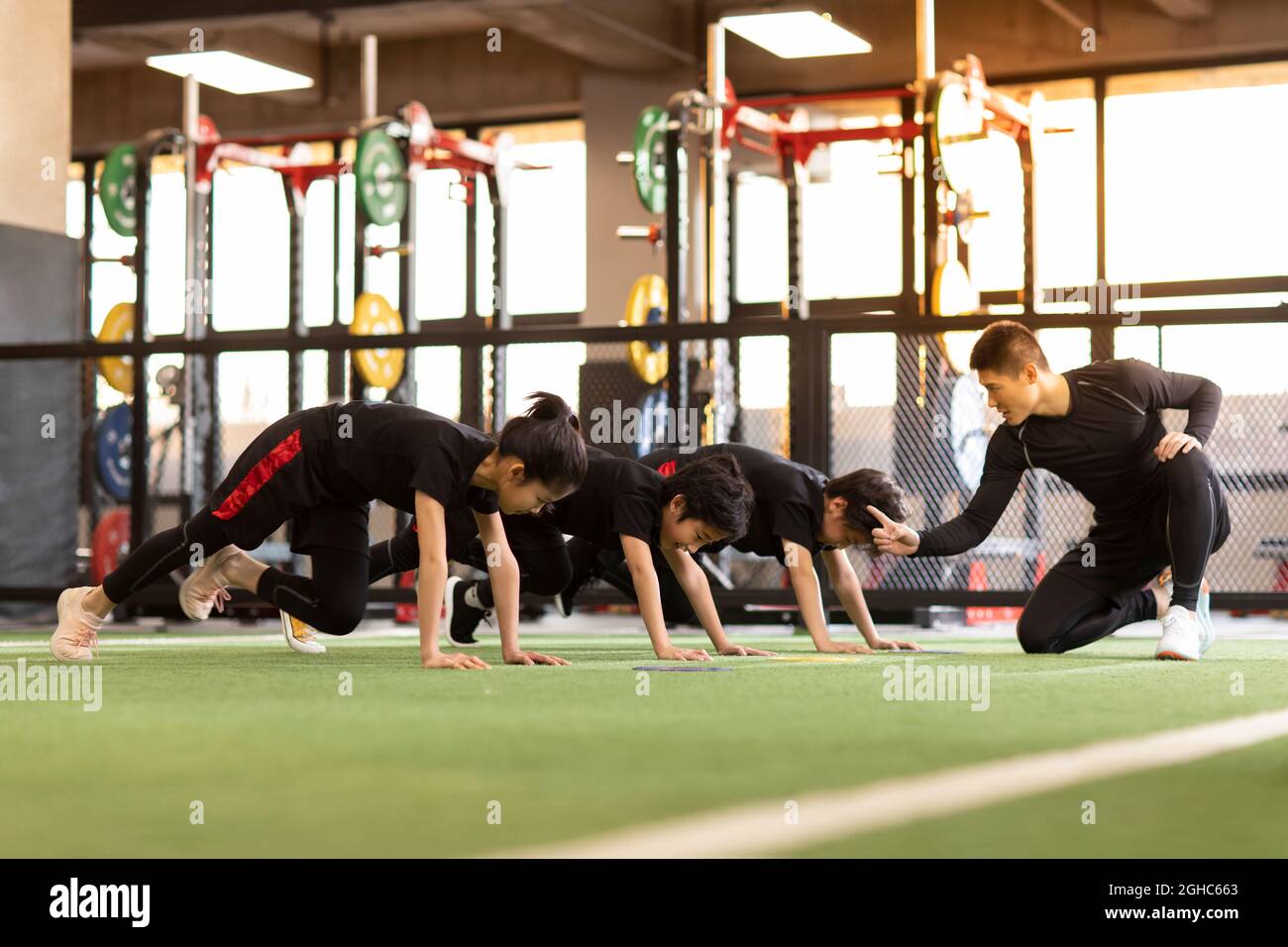Active children having exercise class with their coach in gym Stock ...
