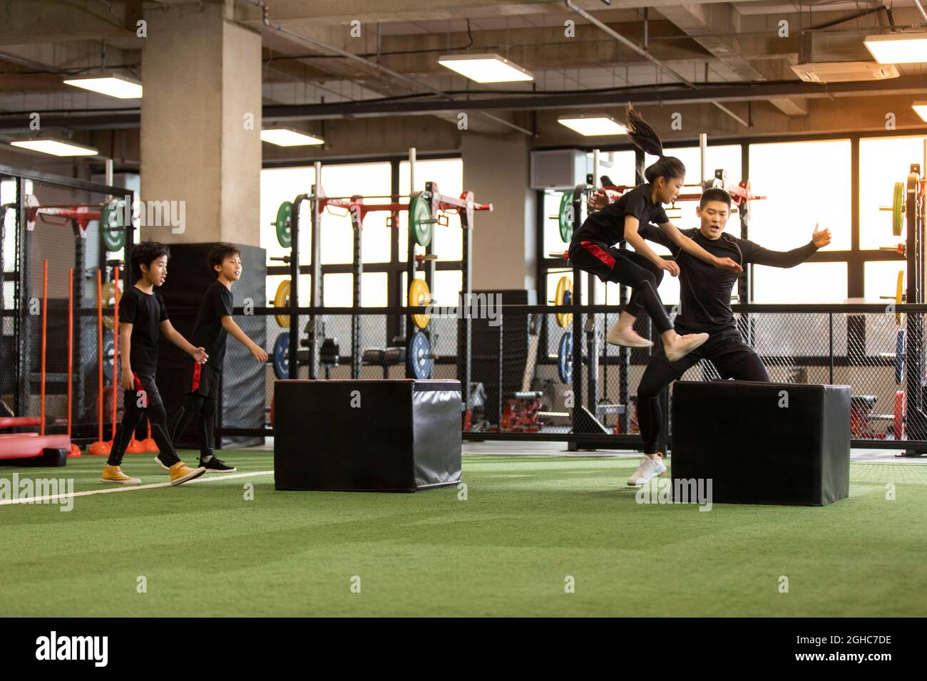 Active children having exercise class with their coach in gym Stock ...