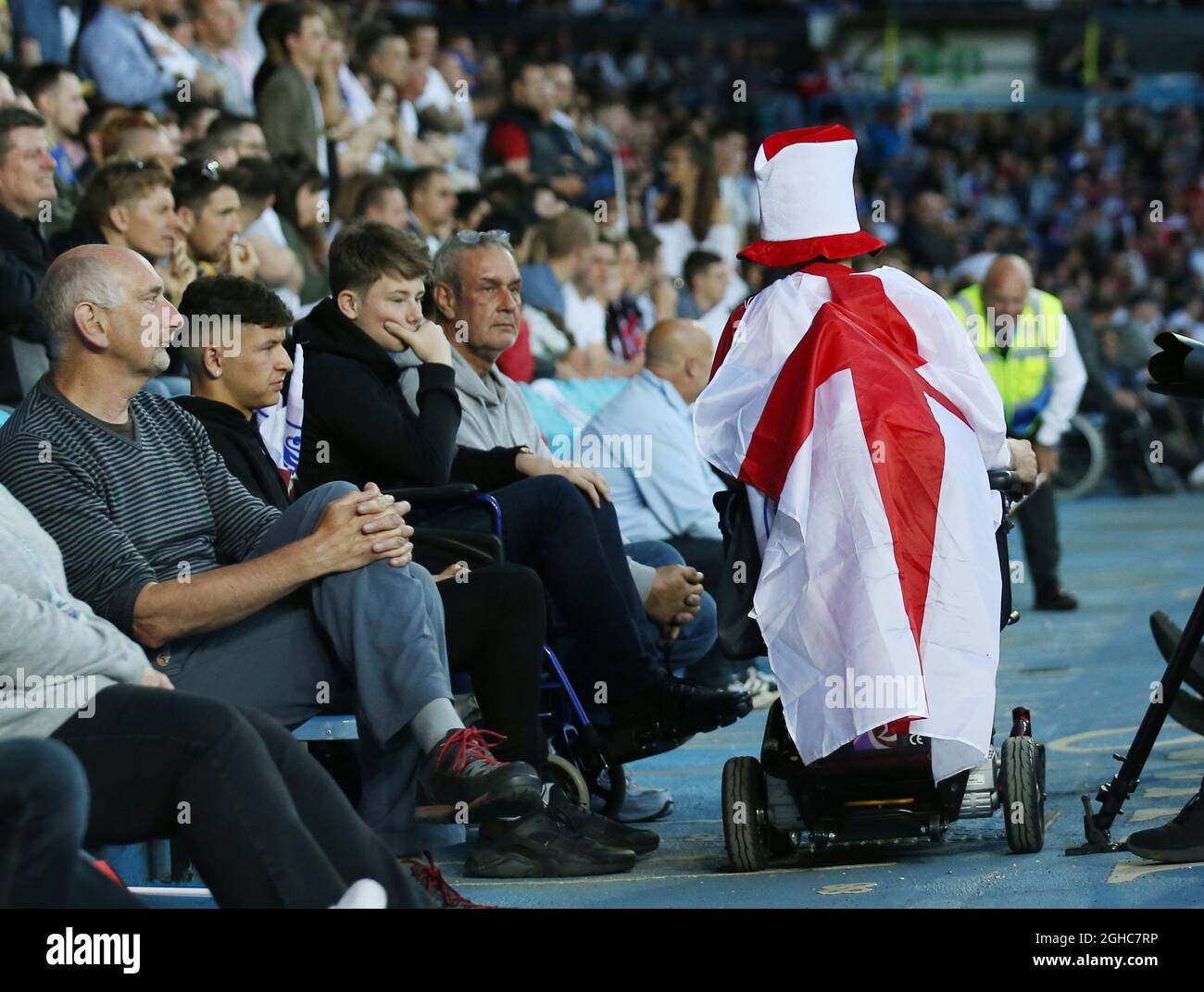 A disabled fan bedecked in England fans makes his way through the ...