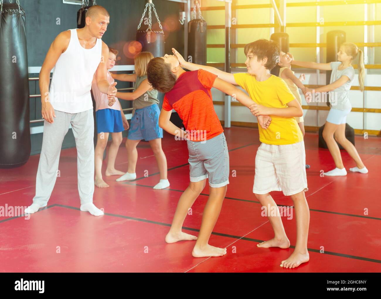 Kids in pairs training chin strike during their self-protection ...