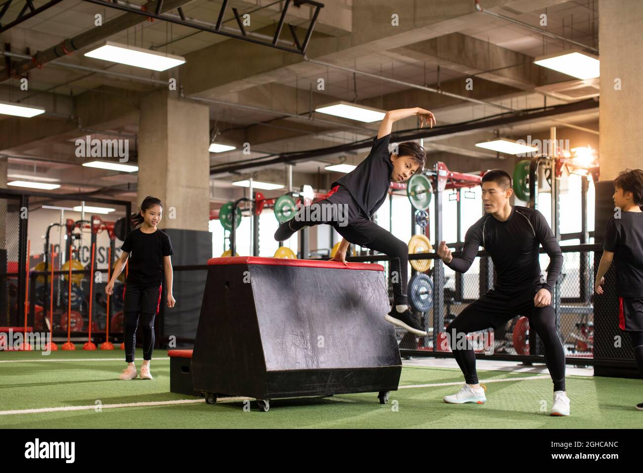 Active children having exercise class with their coach in gym Stock ...
