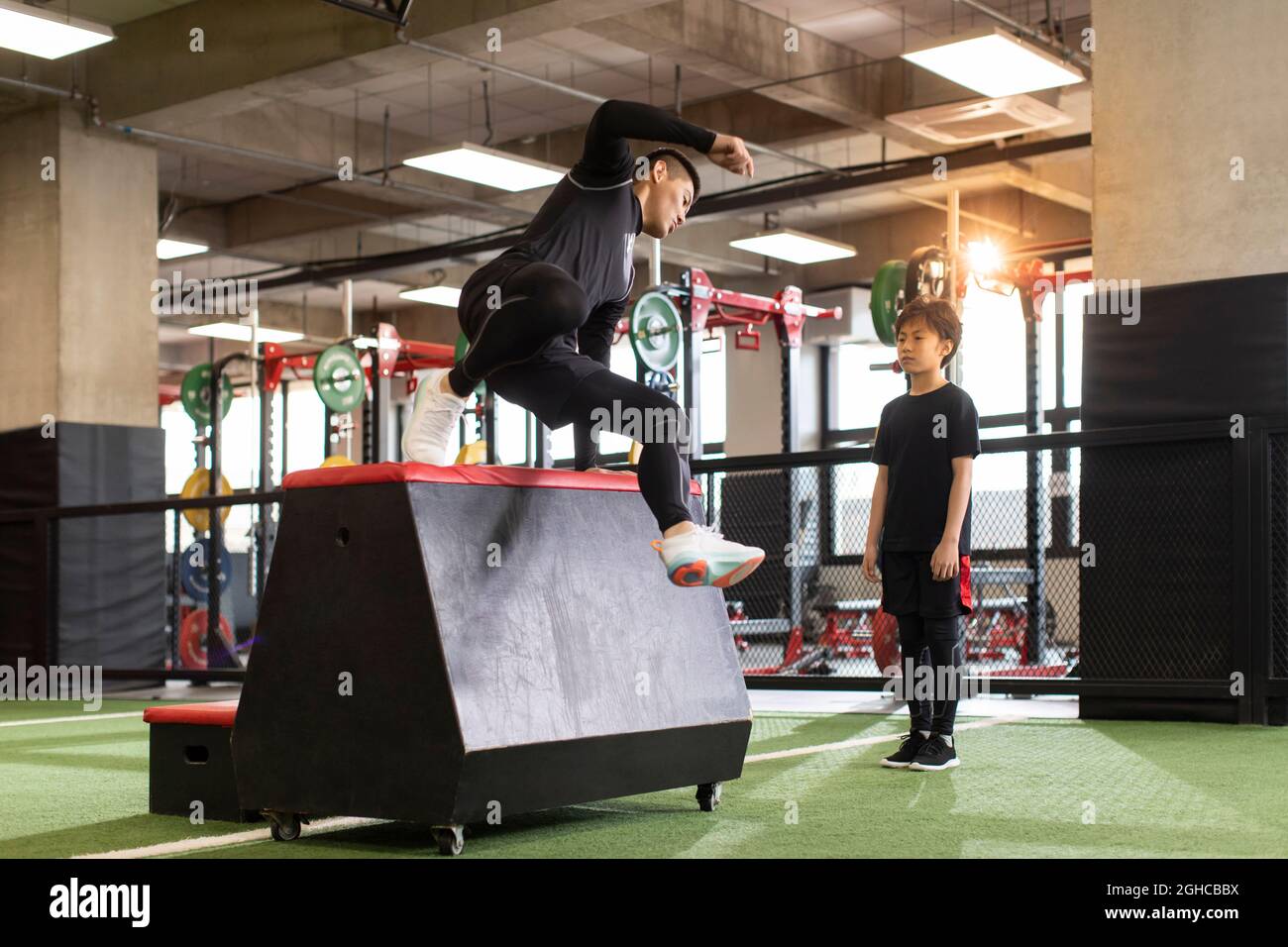 Little boy having exercise class with coach in gym Stock Photo - Alamy