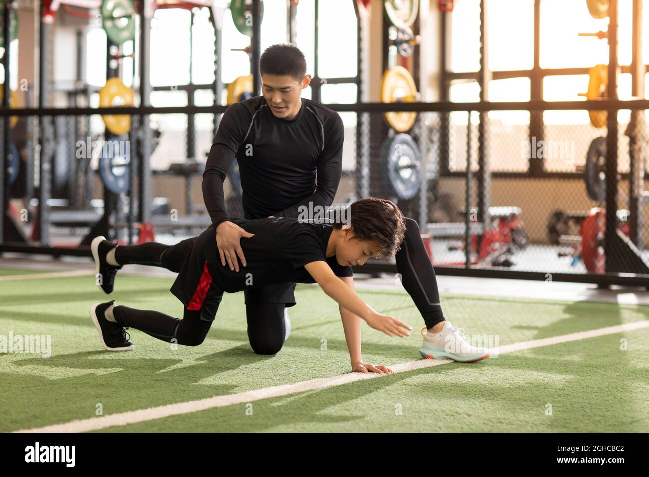 Little boy having exercise class with coach in gym Stock Photo - Alamy