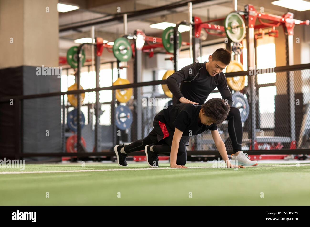 Little boy having exercise class with coach in gym Stock Photo - Alamy