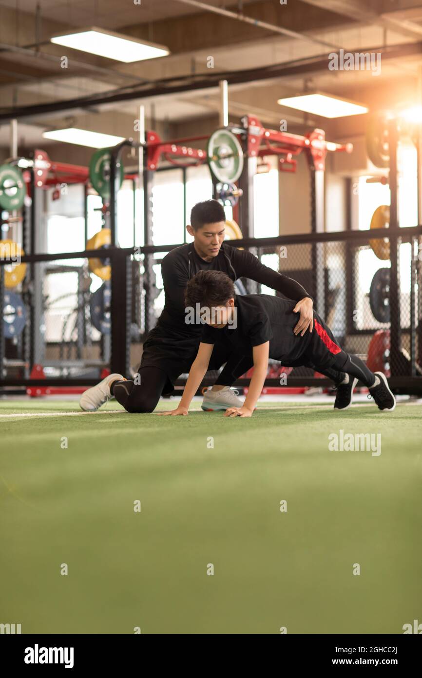 Little boy having exercise class with coach in gym Stock Photo - Alamy