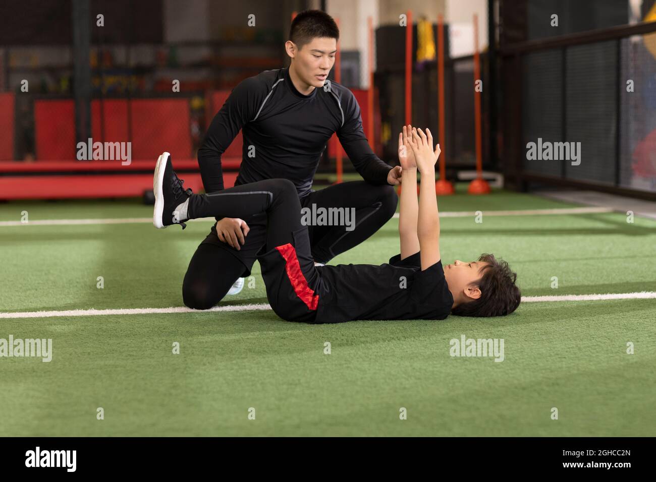 Little boy having exercise class with coach in gym Stock Photo - Alamy