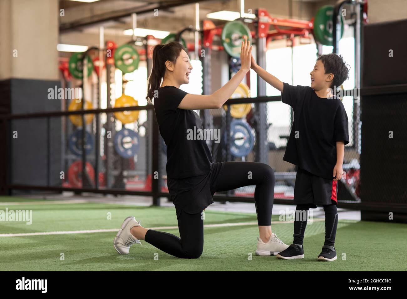 Cute boy and coach high fiving in gym Stock Photo - Alamy