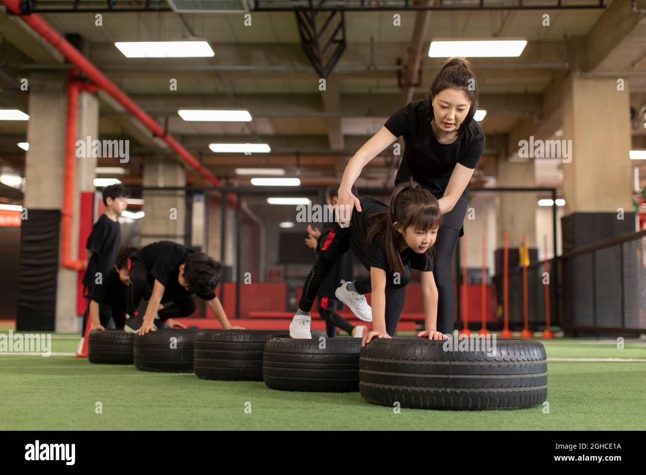 Active children having exercise class with their coach in gym Stock ...
