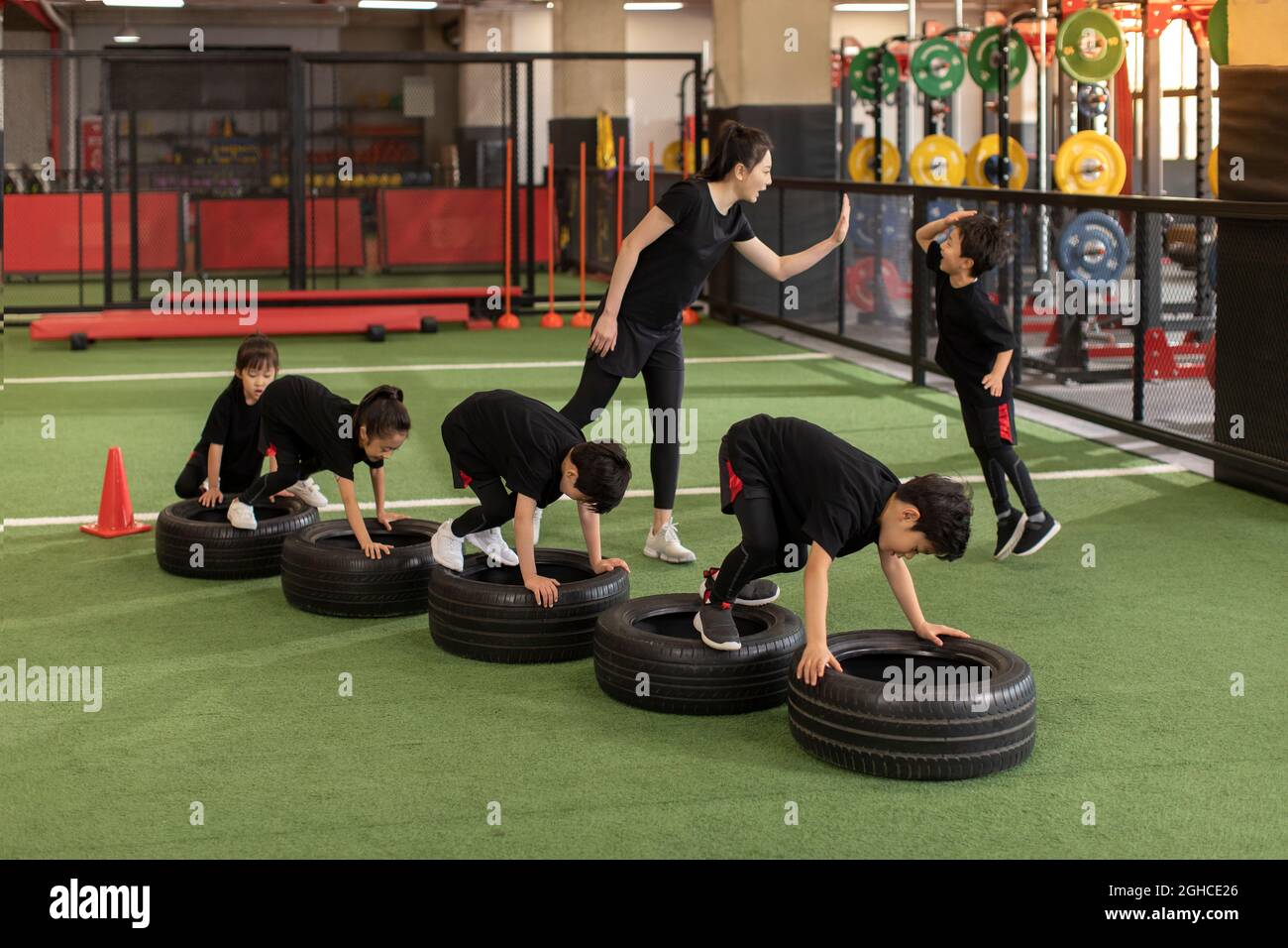 Active children having exercise class with their coach in gym Stock ...