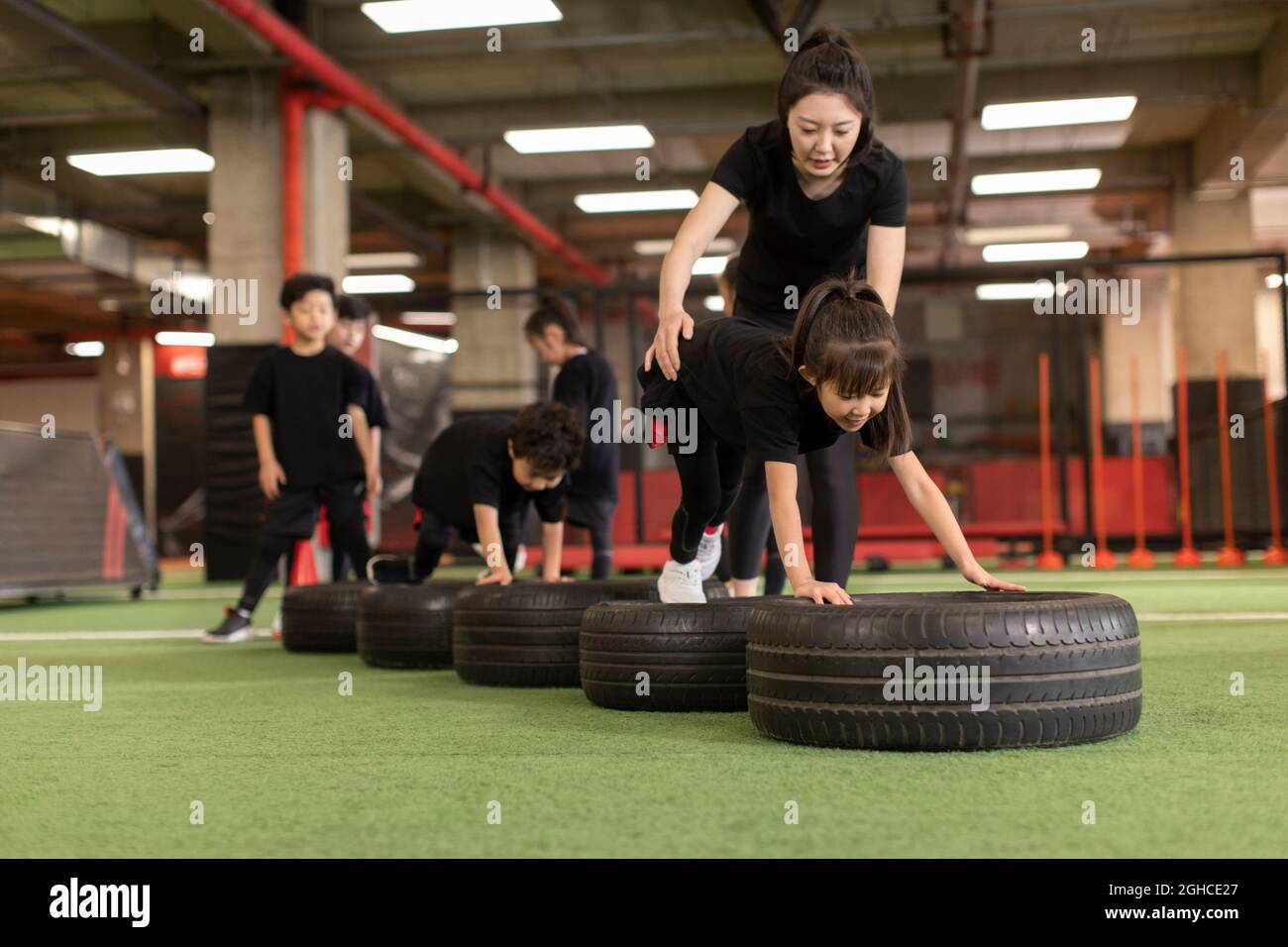 Active children having exercise class with their coach in gym Stock ...