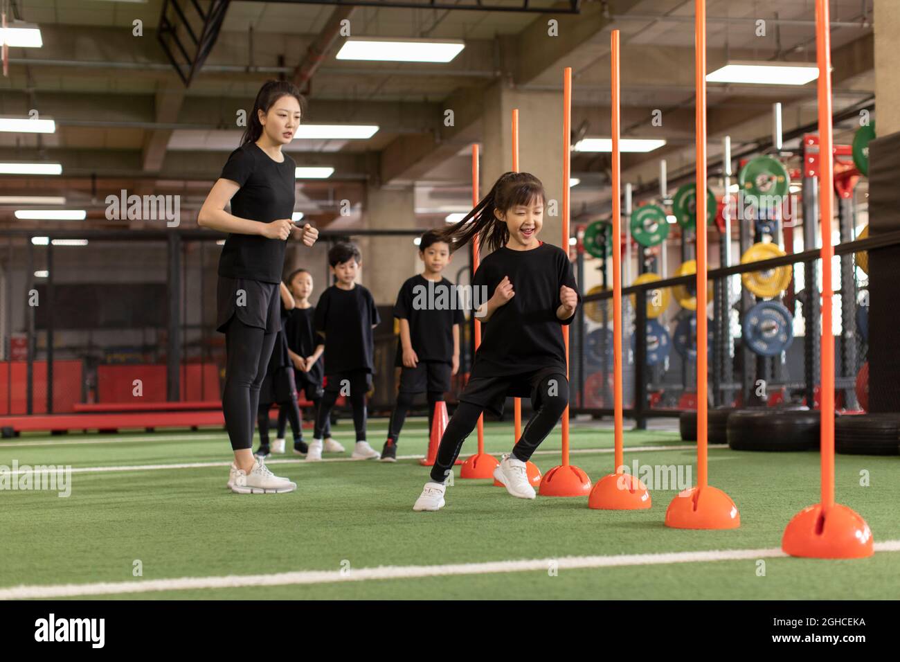 Active children having exercise class with their coach in gym Stock ...