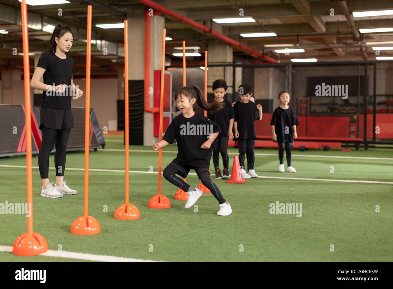 Active children having exercise class with their coach in gym Stock ...