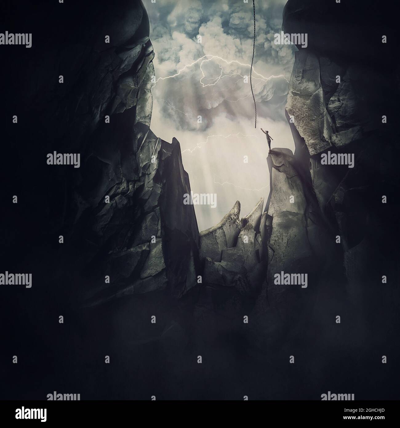 Conceptual scene with a man escaping from the steep chasm, stretching ...